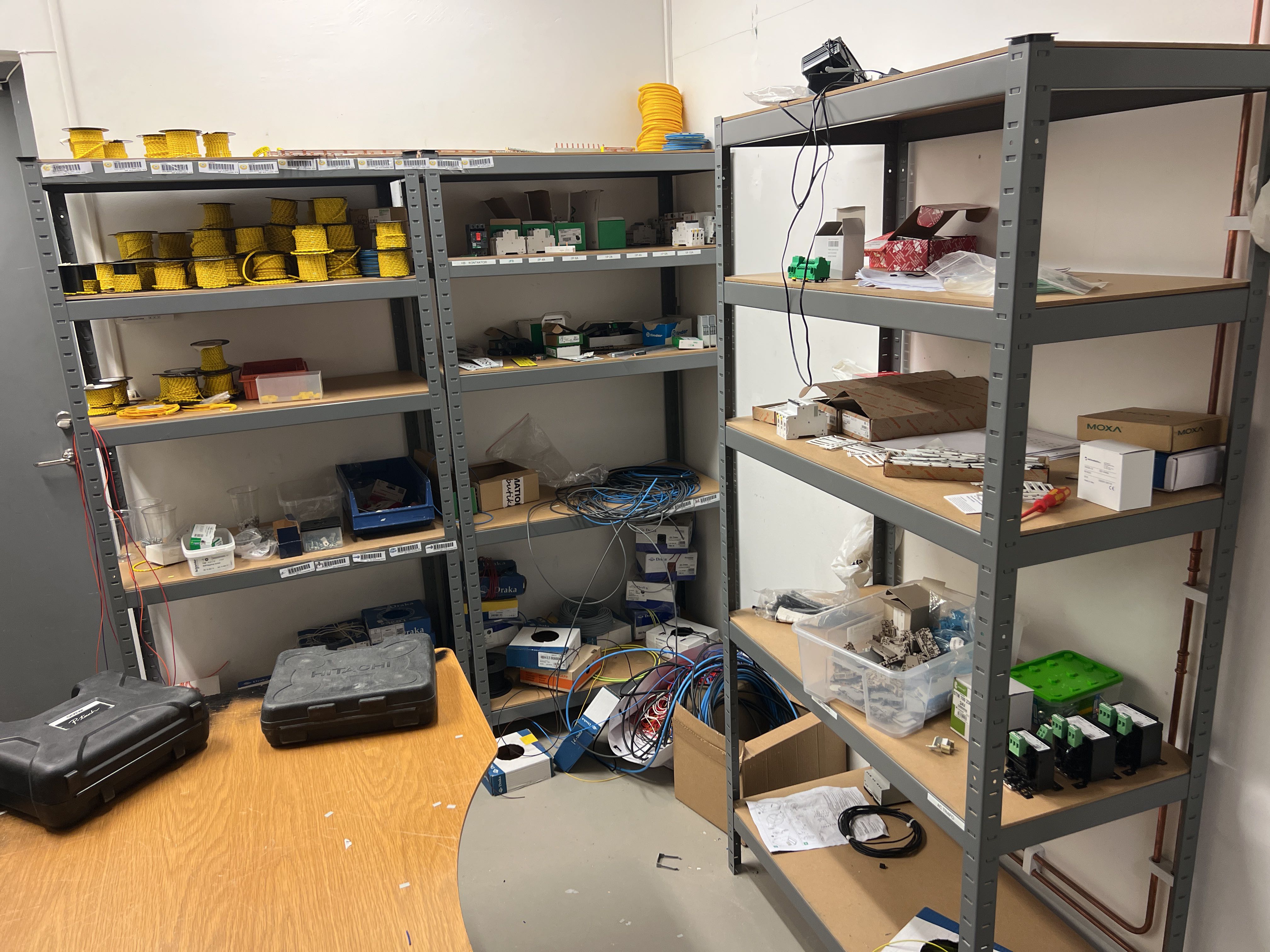 Metal shelves with various electrical installation details and tools ...