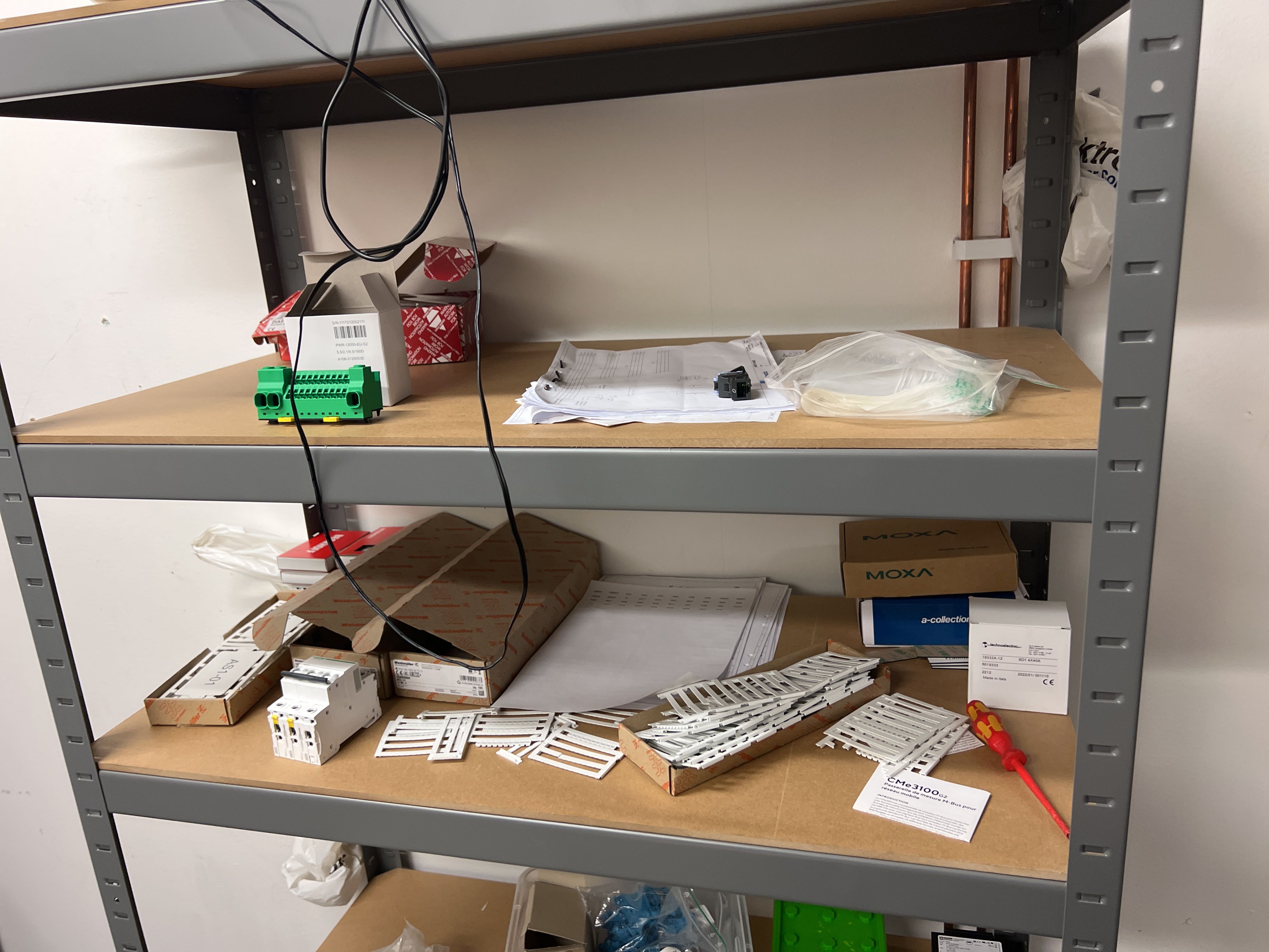 Metal shelves with various electrical installation details and tools ...