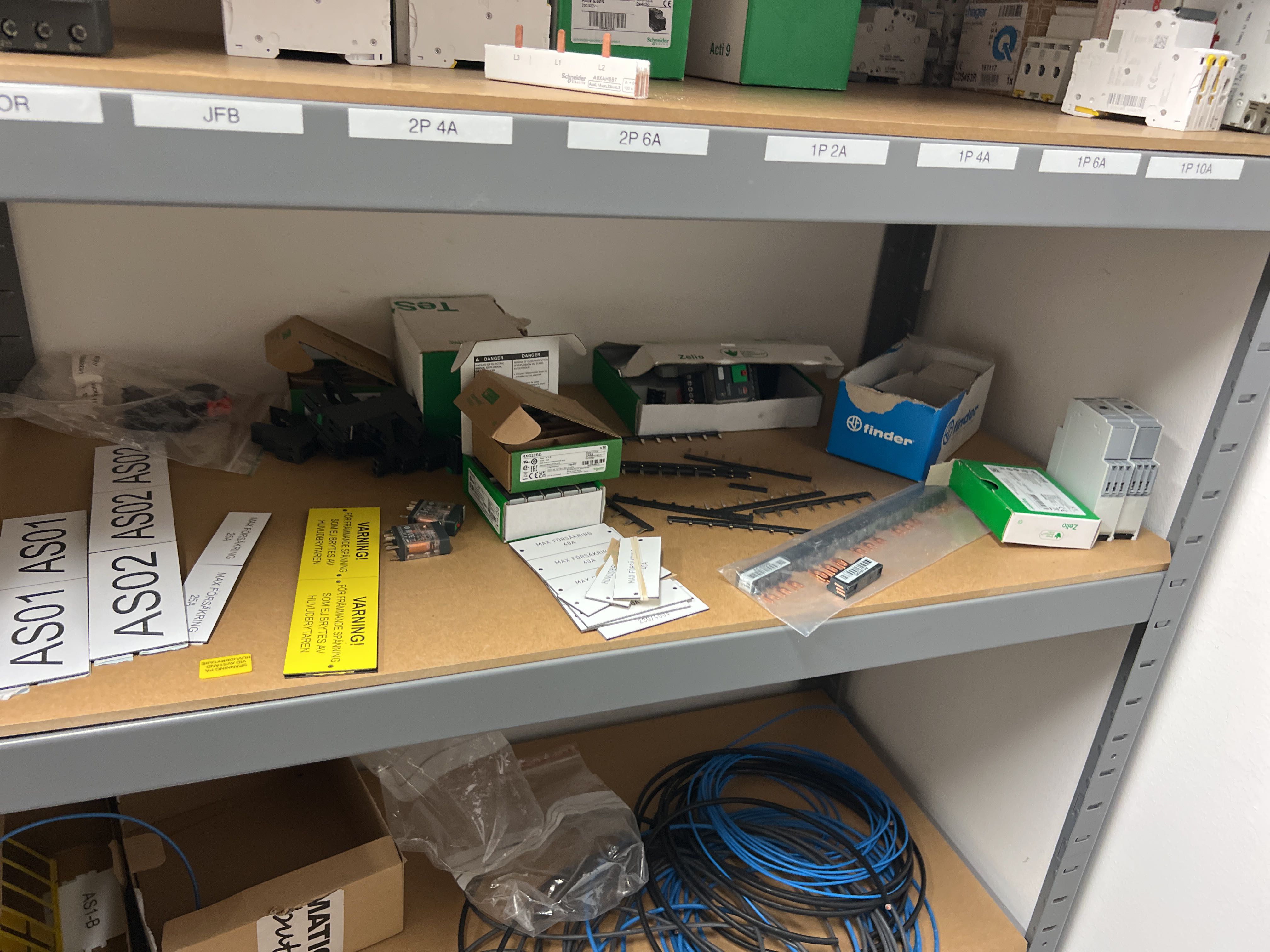 Metal shelves with various electrical installation details and tools ...