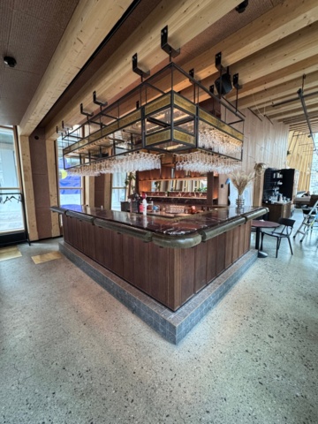 L-shaped bar counter with integrated back bar and wrought iron glass ...